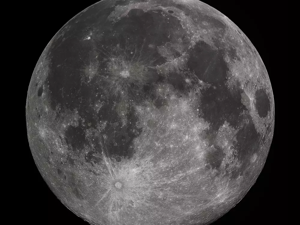 Una imagen de una luna llena. La luna se ve plateada con manchas grises.