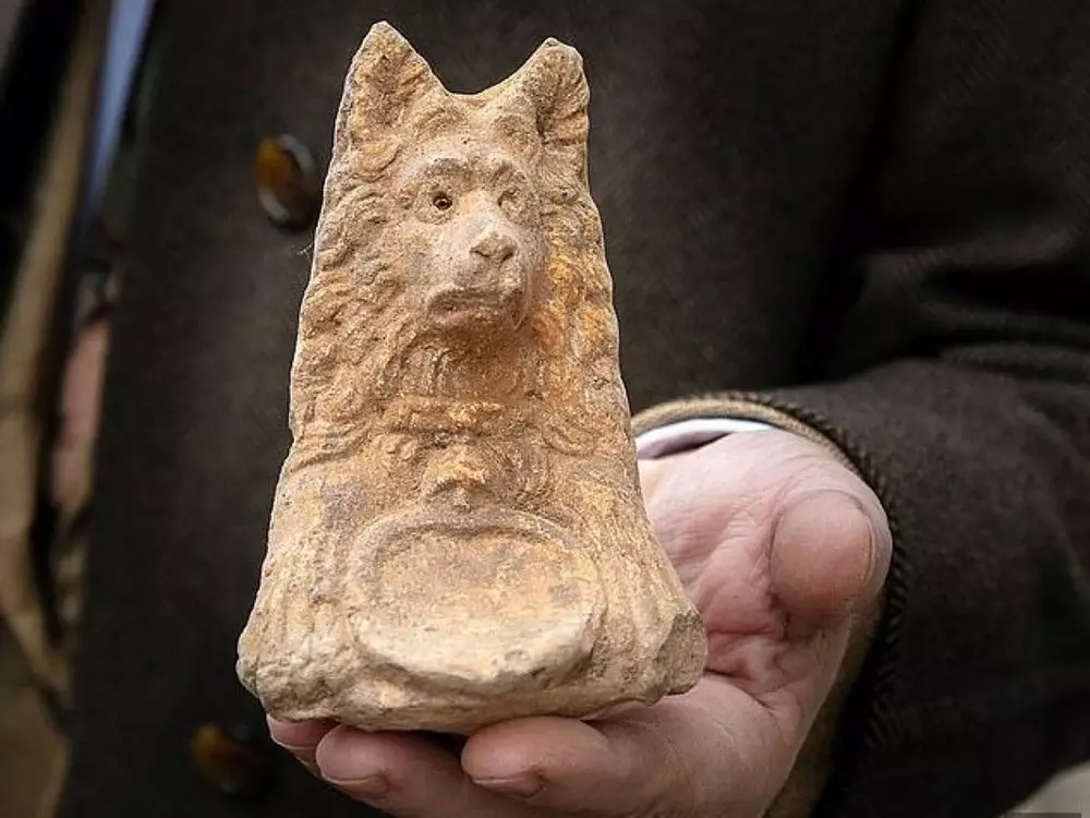 глинена фигура на куче със заострени уши, цвят с голяма емблема и дълга рошава козина