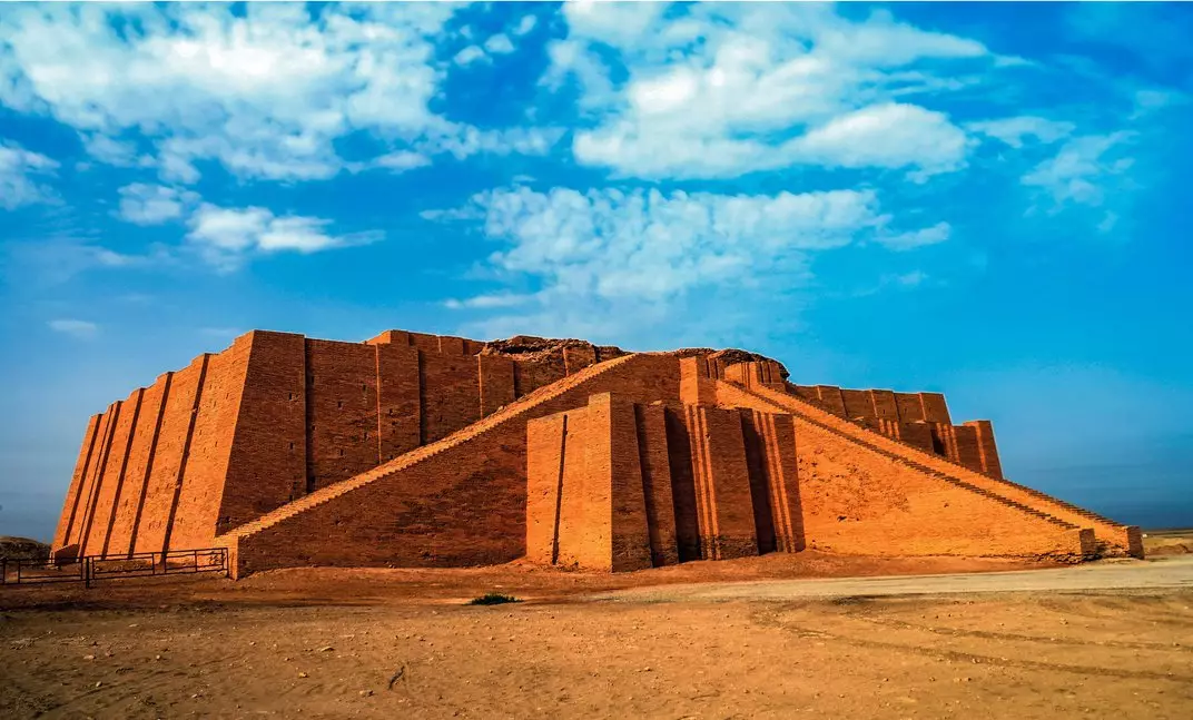 En rød stein ziggurat, et trappet tårn, omgitt av ørken