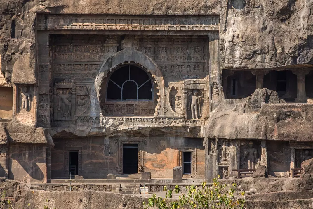 Akmens tempļa ieeja ar trim durvīm un lielu arkveida logu, kas izgrebts klints sejā