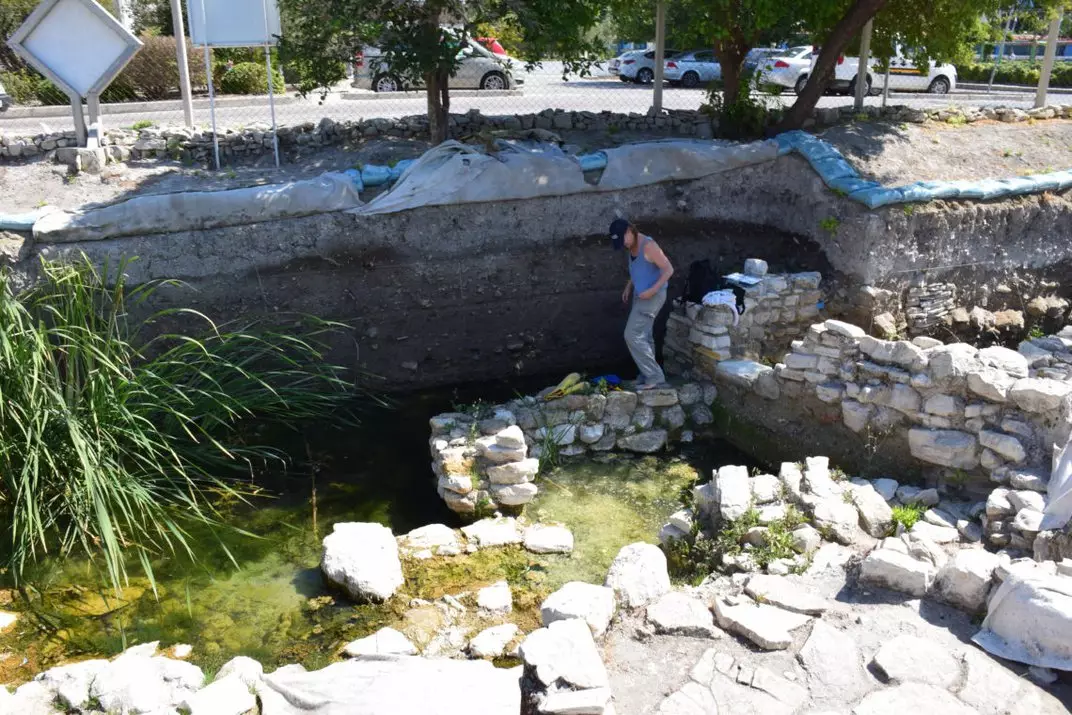 Gizon arkeologoa harri-harrobi batean indusketa gunean lanean