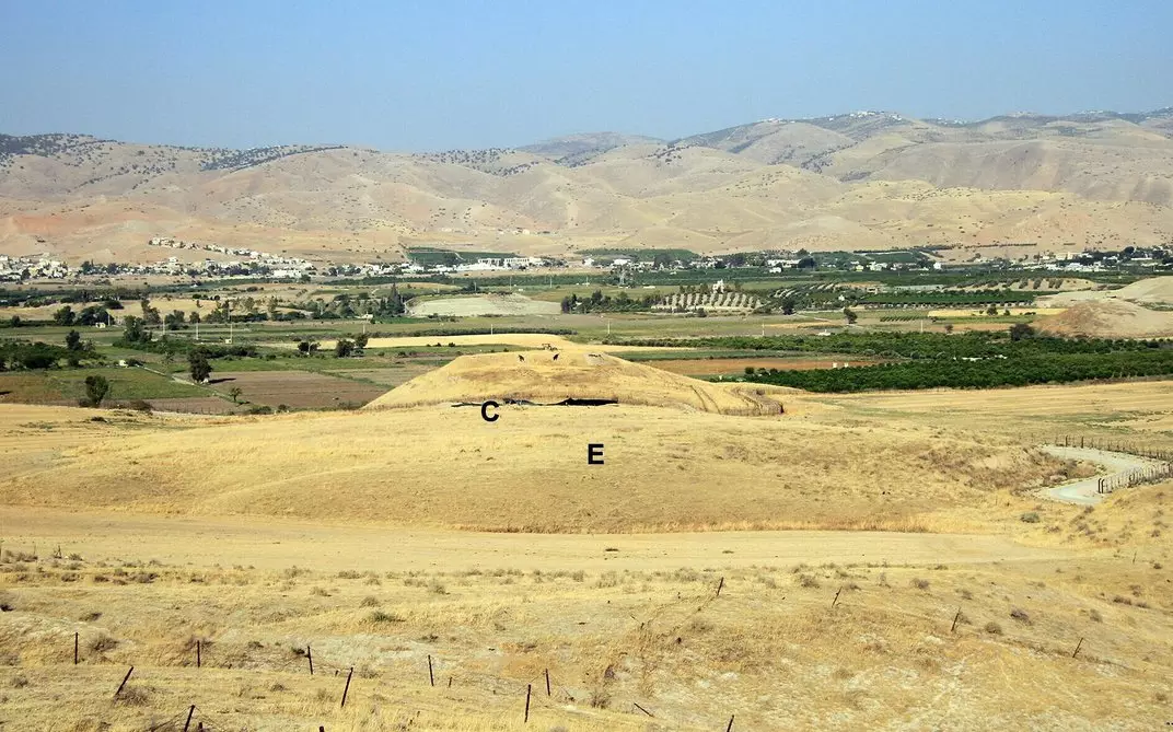 vaizdas į kalvotą smėlio kraštovaizdį, kuriame yra kasimo vieta