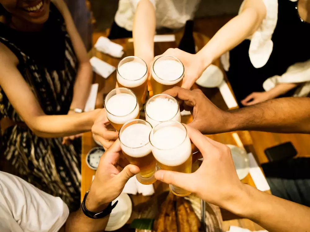一群朋友一起喝满啤酒杯