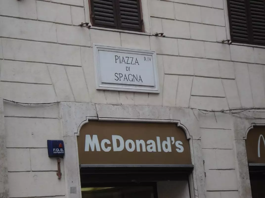 Cartel de McDonald's bajo el cartel de Piazza di Spagna