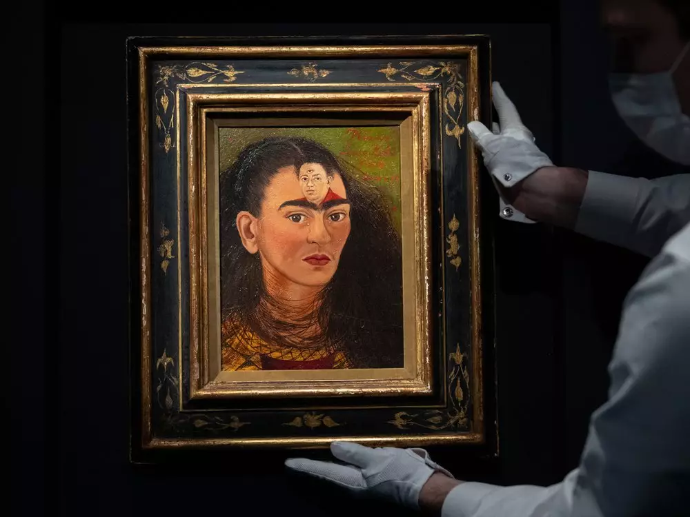 Kahlo autoportree kaelast üles, tumeda juuksepilve, sügavpunase särgi ja huultega ning kolme pisikese pärlipisaraga; tema kulmuluul toetub väike portree Diegost kolme silmaga