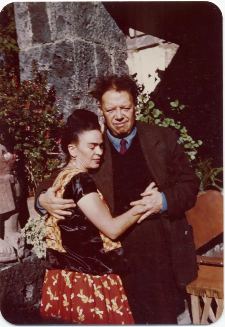 Kahlo ja Rivera kallistamas ja silmi kissitamas eredas päikesevalguses, õues