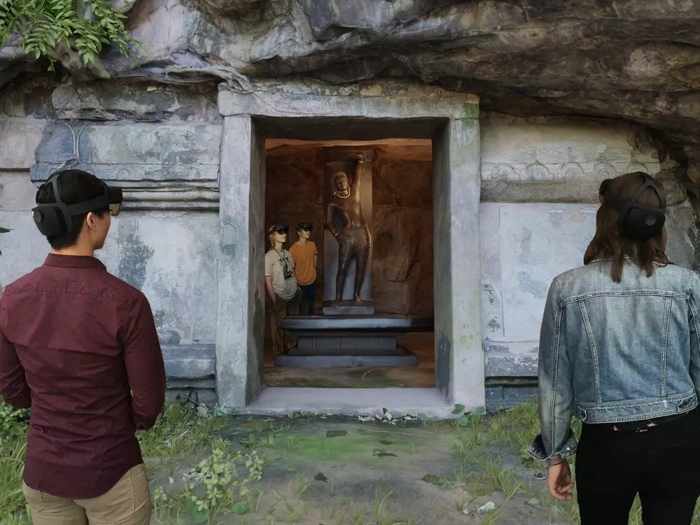 Unha representación da experiencia de realidade virtual, que mostra unha cova artificial cortada na ladeira dunha montaña para revelar unha estatua de Krishna