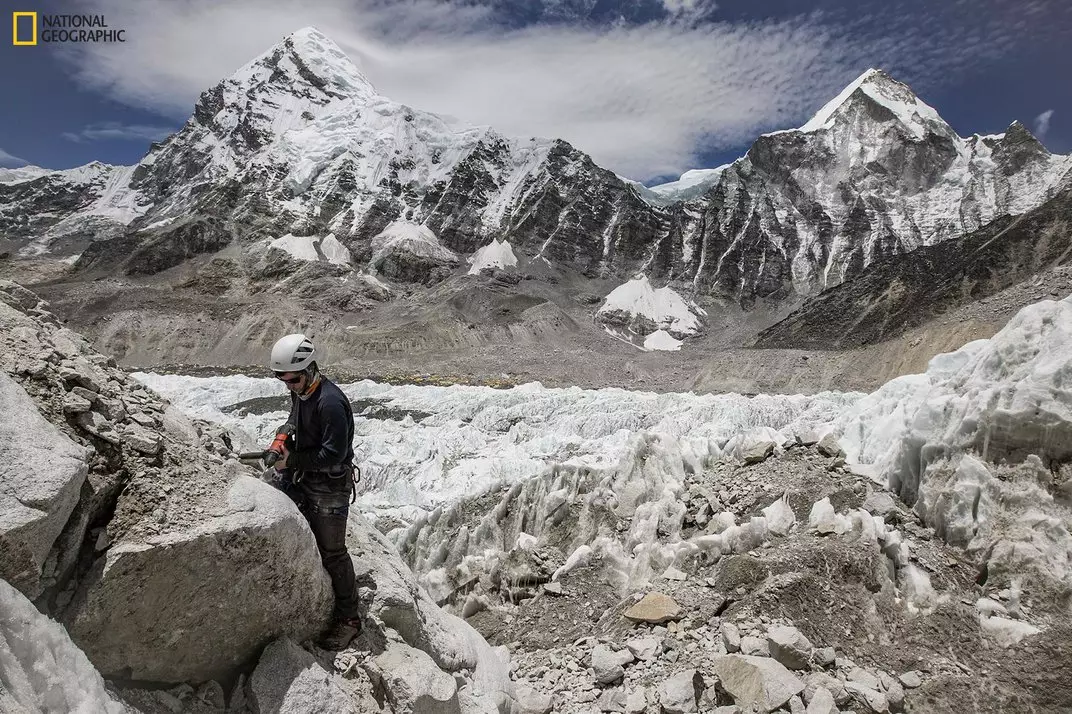 Член команды National Geographic и Rolex Perpetual Planet Everest Expedition берет образец из обнажения скалы рядом с ледопадом Кхумбу над базовым лагерем Эвереста.