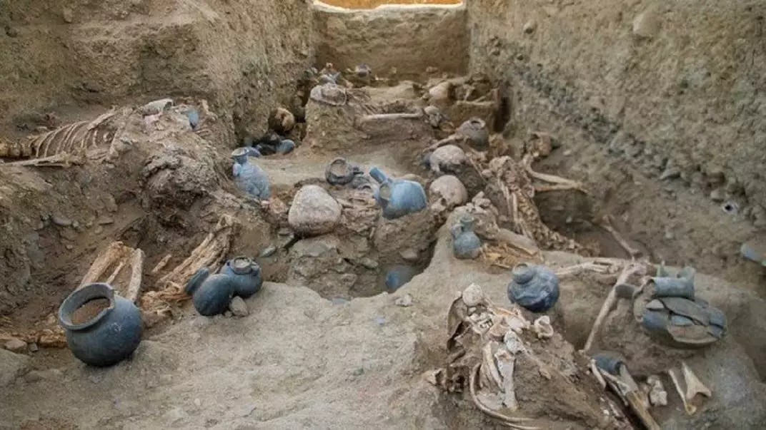 Поглед на масовна гробница, со сини садови и скелети видливи