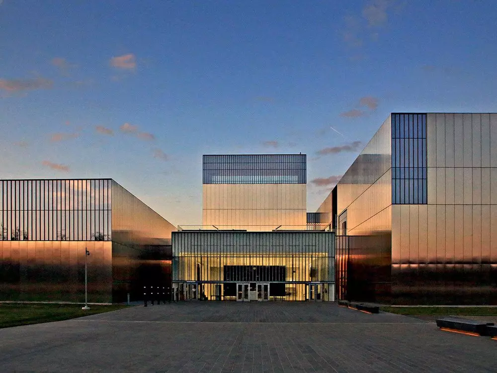 Slika velikog, kutijastog muzeja s fasadom od poliranog nehrđajućeg čelika i pravokutnim prozorima; veoma moderno