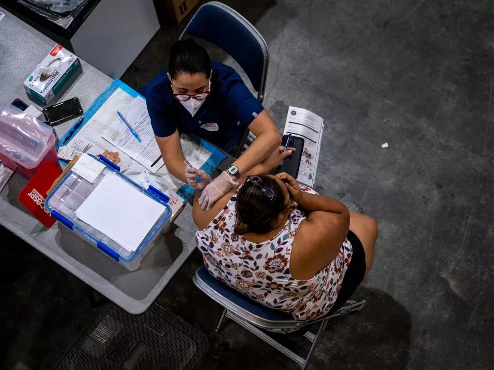 Et bilde av en helsepersonell som gir et skudd ved møtesenteret i Puerto Rico under en vaksinasjonsbegivenhet.