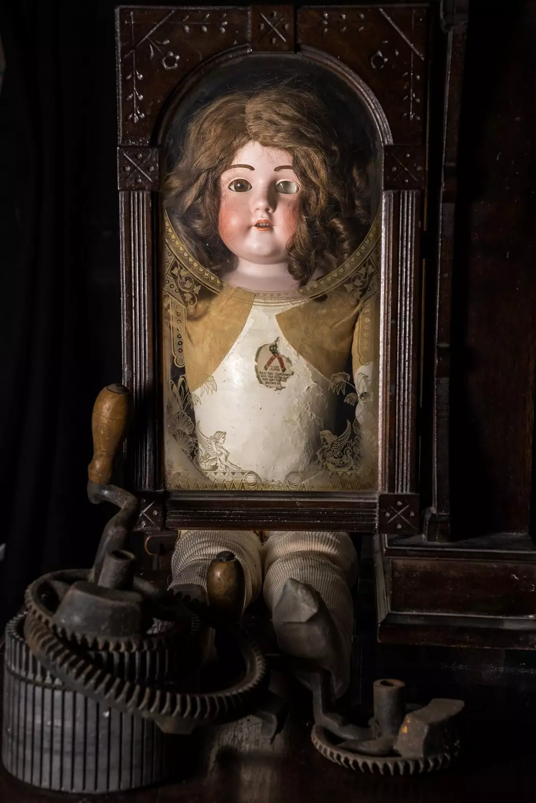muñeca enmarcada en ventana antigua