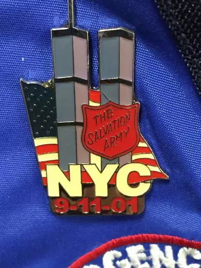 Pin mit rotem Siegel der Rettungsarmee und grauen Twin Towers auf Hintergrund der amerikanischen Flagge