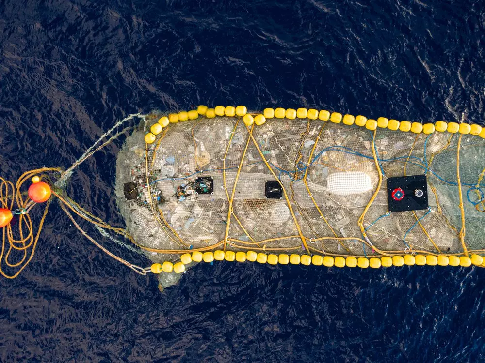 Foto Ariel de dispositivo de coleta de lixo semelhante a linhas de pista de piscina flutuante com uma grande rede cheia de lixo plástico