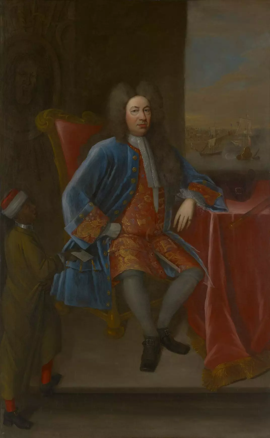 Elihu Yale'o, balto vyro su peruku ir raudonos ir mėlynos spalvos puošmena, sėdinčio prie raudonu aksomu padengto stalo, portretas. Vyras tamsiai ruda oda prieina prie jo iš kairės nuo drobės ir siūlo laišką