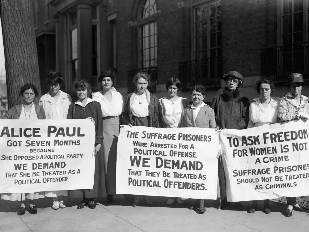 suffragists memegang papan tanda menuntut rawatan tahanan politik untuk Alice Paul