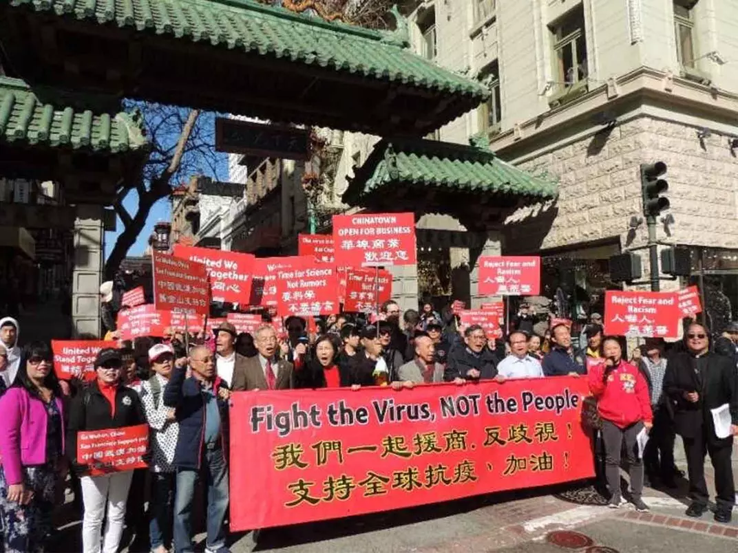 Los manifestantes de Chinatown llevan una pancarta que dice