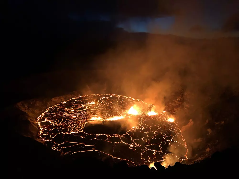 Kīlauea вулкан саммитында урнашкан Халемаума кратеры эчендә ялтырап торган кызыл ярыкларның образы.