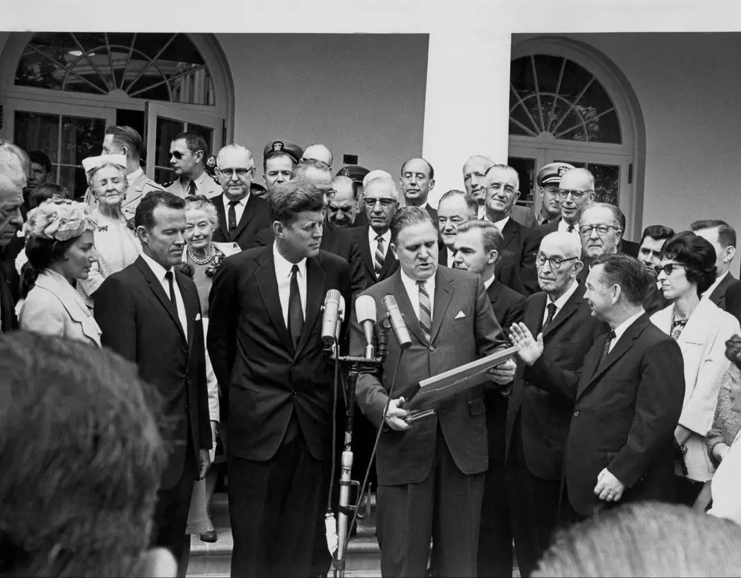 Photo en noir et blanc d'une foule de personnes, dont James Webb, recevant une plaque du président Kennedy à Washington DC