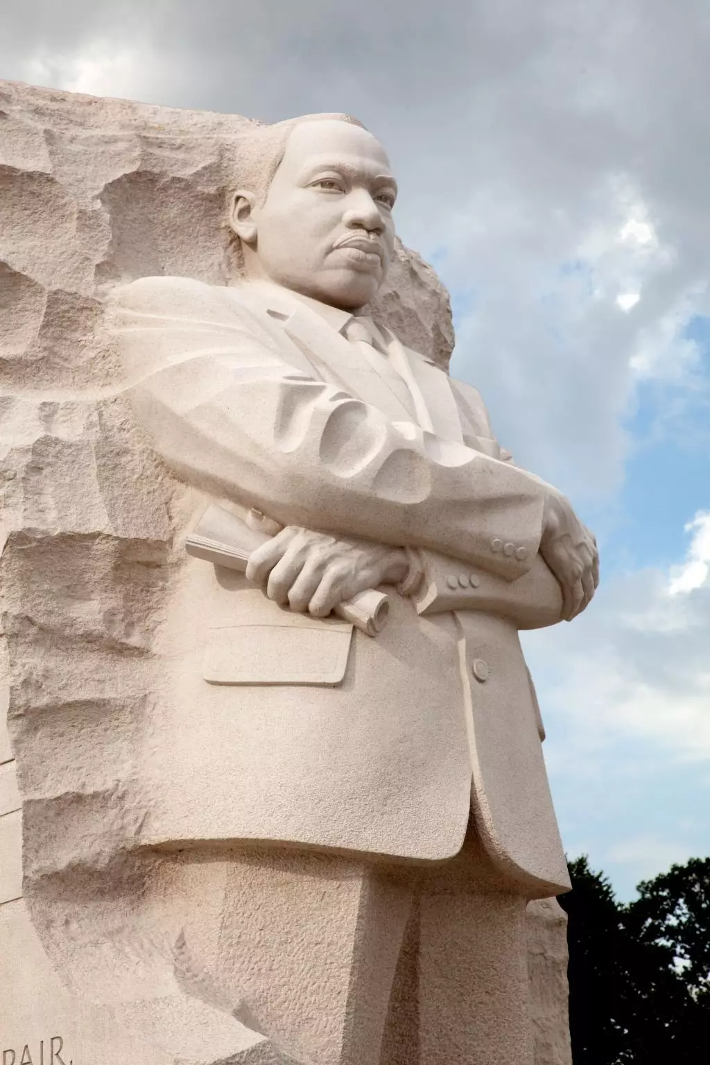Unha estatua branca tallada de MLK Jr, que se ergue cos brazos cruzados sobre o peito