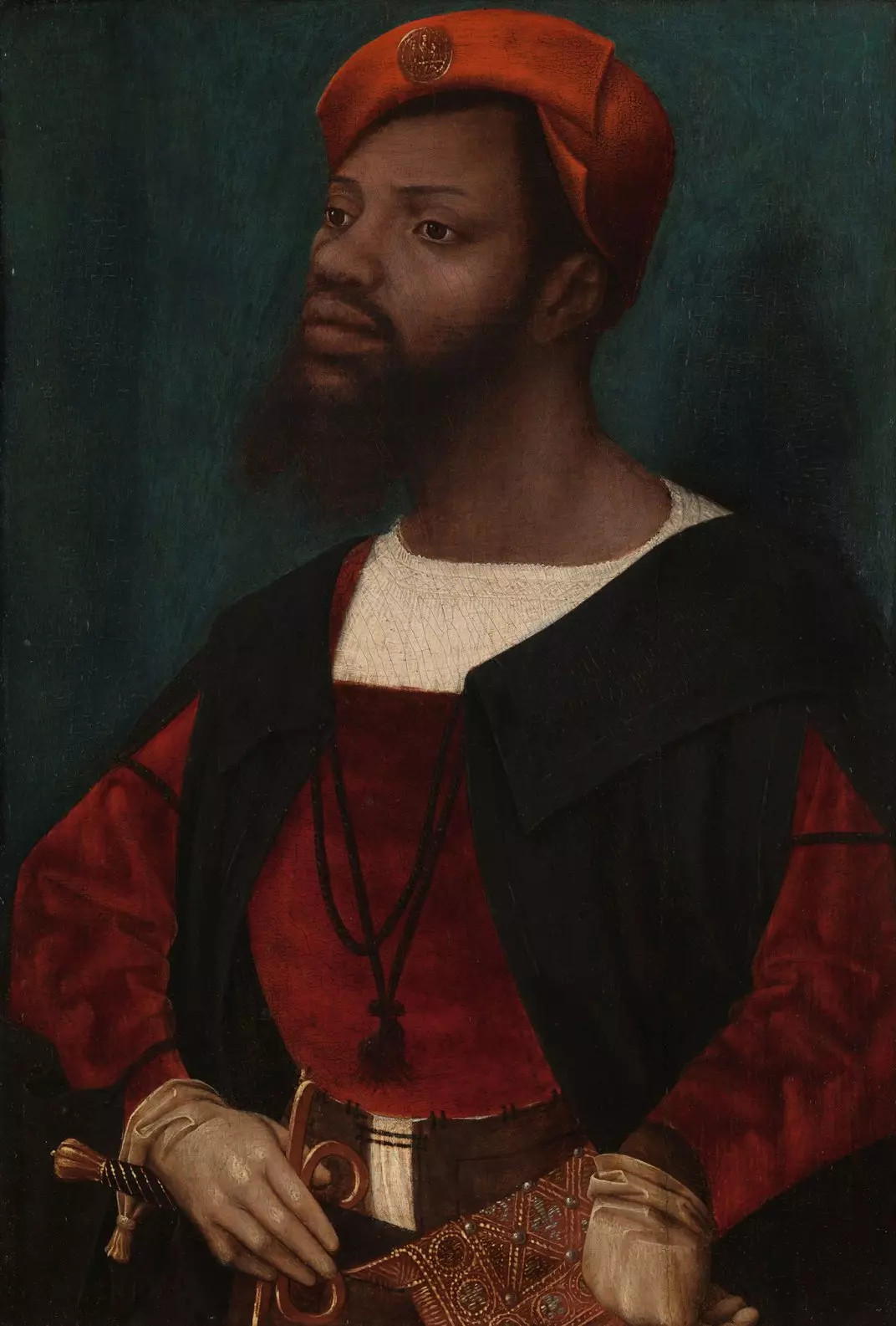 Un portrait d'un homme noir avec une barbe, en robe élégante et coûteuse et posé avec son menton levé dans une position confiante
