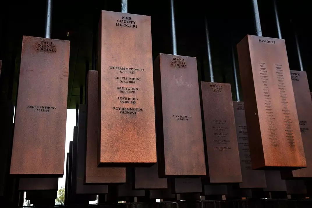 ブロンズ、ブラウンオレンジ色の大きな鋼の長方形は、リンチの犠牲者を参照する碑文を付けて隣り合ってぶら下がっています。