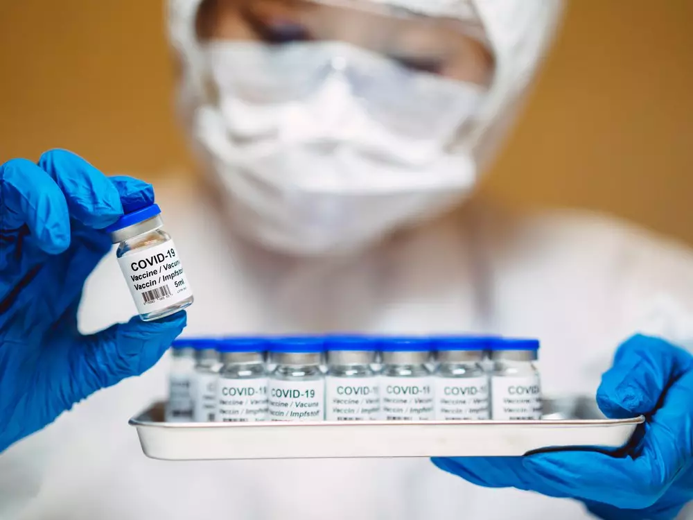 一般的なCovid-19ワクチンのトレイを保持している医療従事者の段階的なストック画像