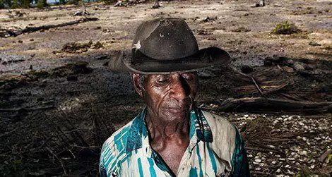 Posakei Pongap, mieszkaniec wyspy Manus, przed polem zniszczonym przez zasolenie.