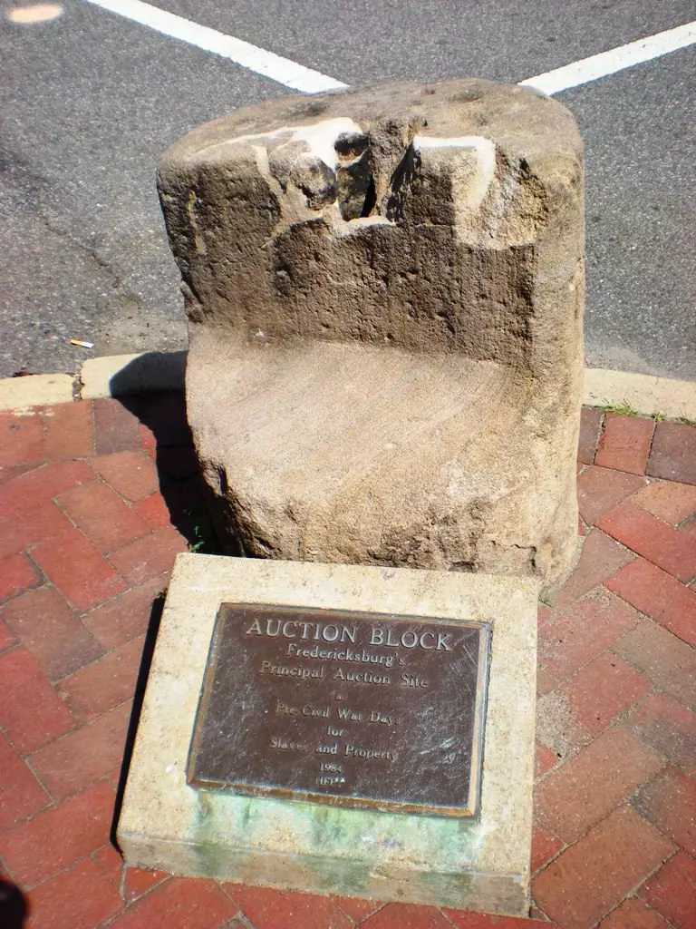 سڑک کے ایک کونے پر ایک پتھر کا بلاک جس کے سامنے ایک تختی ہے جس پر نیلامی کا بلاک لکھا ہوا ہے۔