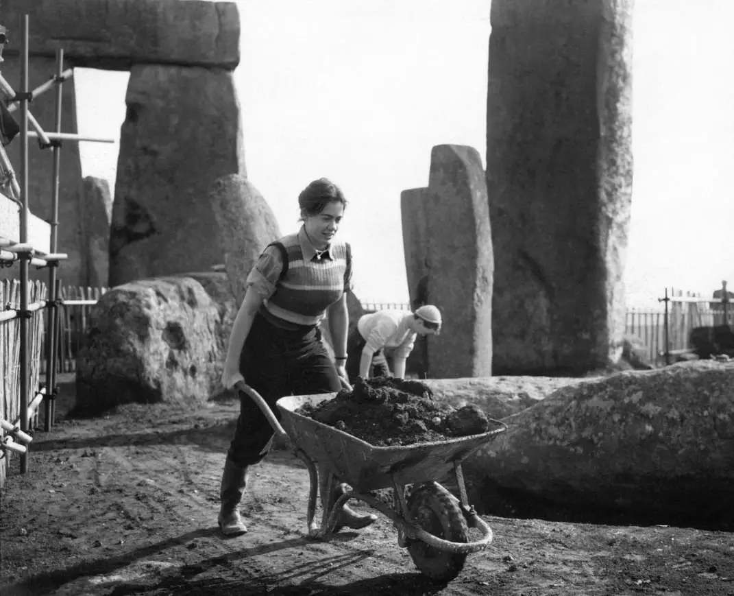 Sally Kistruck, et medlem av Edinburgh University-teamet, triller bort en gravhaug med jord under utgravningen og restaureringen i 1958.