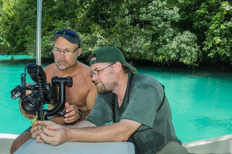 水の上でカメラを通して見ている2人の男性
