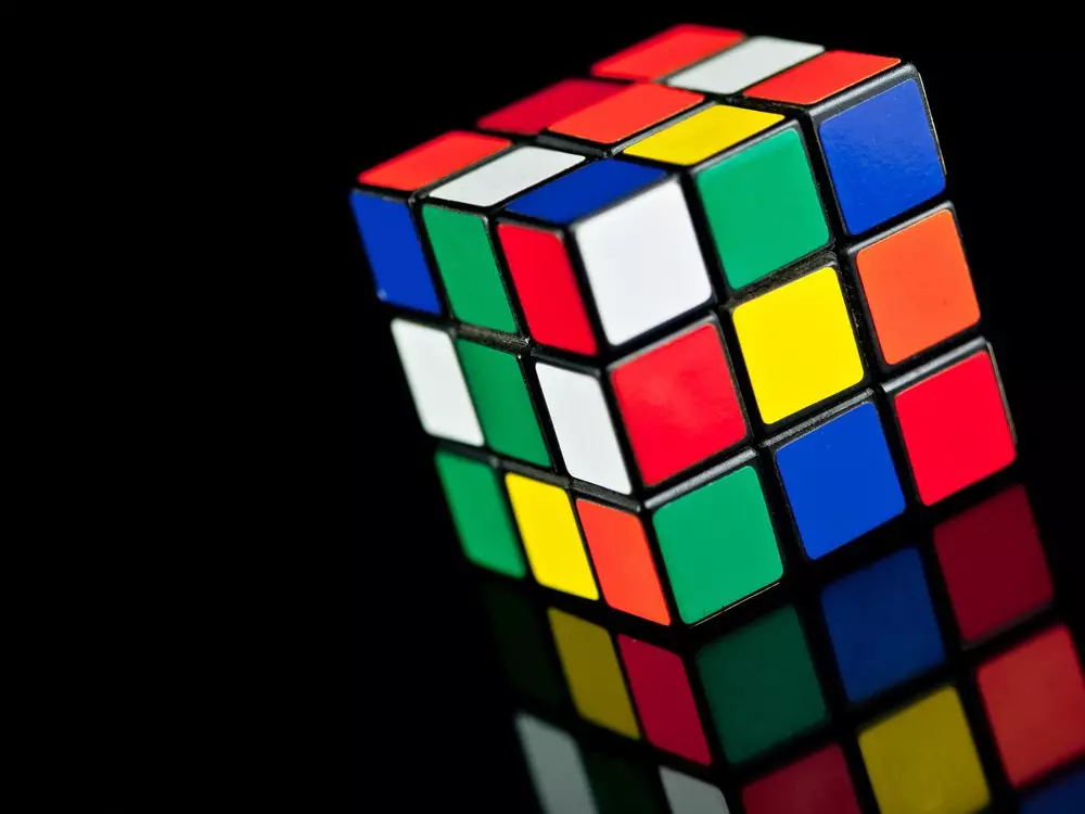 အနက်ရောင်နောက်ခံတွင် ရောင်ပြန်ဟပ်သည့် Rubik's Cube အရုပ်။
