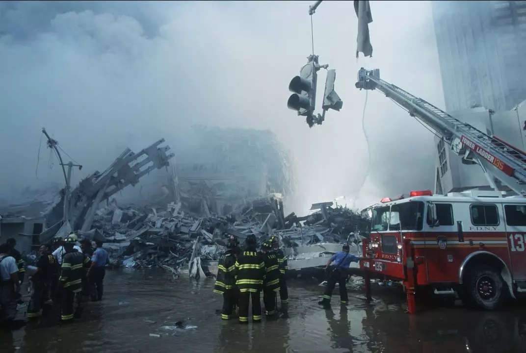 Näkymä Ground Zerolle, jossa vesi oli tulvinut suurimman osan kohtauksesta ja liikennevalo roikkuu langan päällä tapahtumapaikan päällä. Paloauto istuu lähellä.