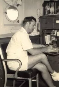 Le lieutenant Minter Dial dans la cabine du capitaine de l'U.S.S. Napa, rédigeant une lettre à l'automne 1941.