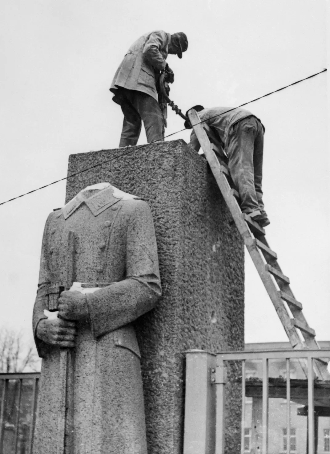 1945 жылы Берлиндегі жұмысшылар қазір АҚШ әскерлері басып алған казарманың жанындағы нацистік солдаттың басы жоқ мүсінінің үстіне көтерілді. Кейінірек мүсін де-нацификация бағдарламасының бір бөлігі ретінде бұзылды.