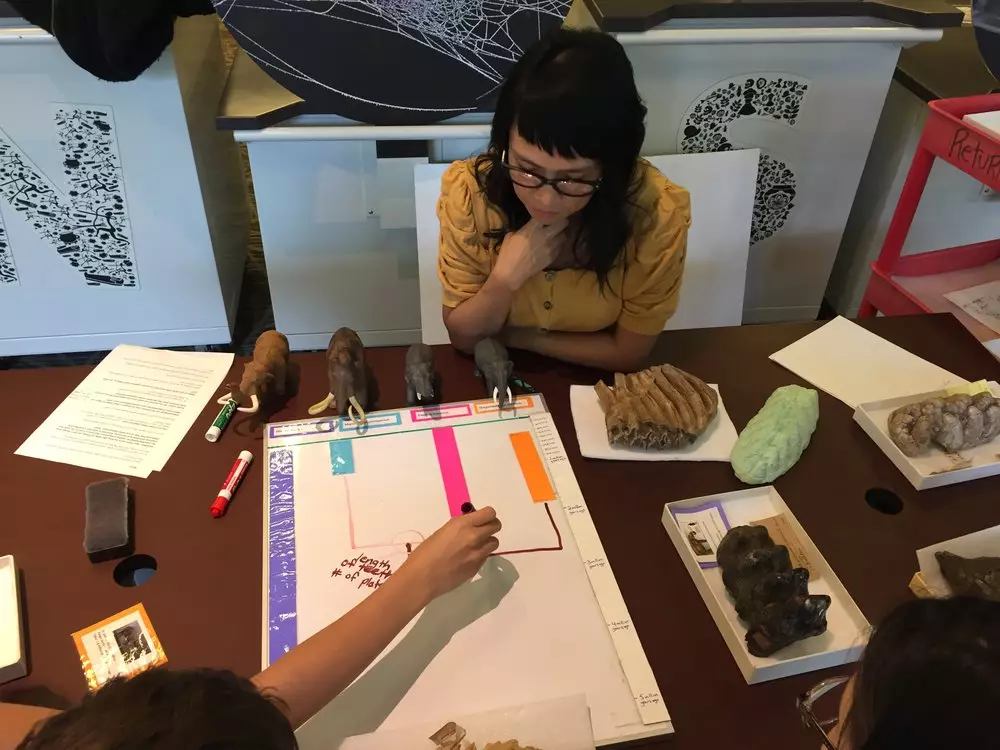 Education Specialist Gale Robertson helps museum visitors test prototypes of hands-on activities that will be in “The David H. Koch Hall of Fossils—Deep Time” when it opens June 8 at the Smithsonian’s National Museum of Natural History. (Smithsonian Institution) 