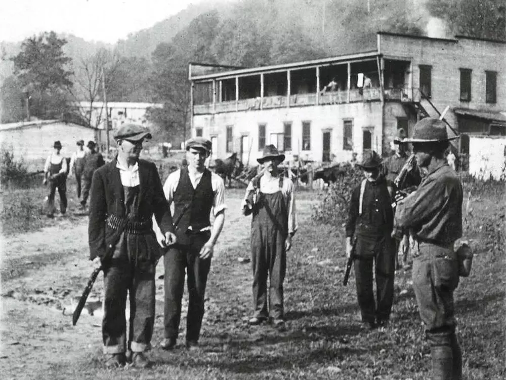 Tres mineros con soldado federal se preparan para entregar las armas.
