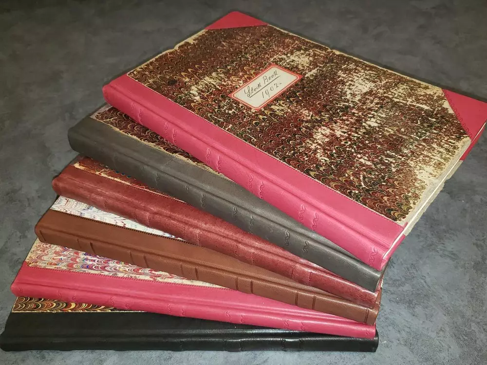 کتابهای استوک با جلدهای مرمری و صحافی چرمی در رنگهای مختلف بادکش شده.