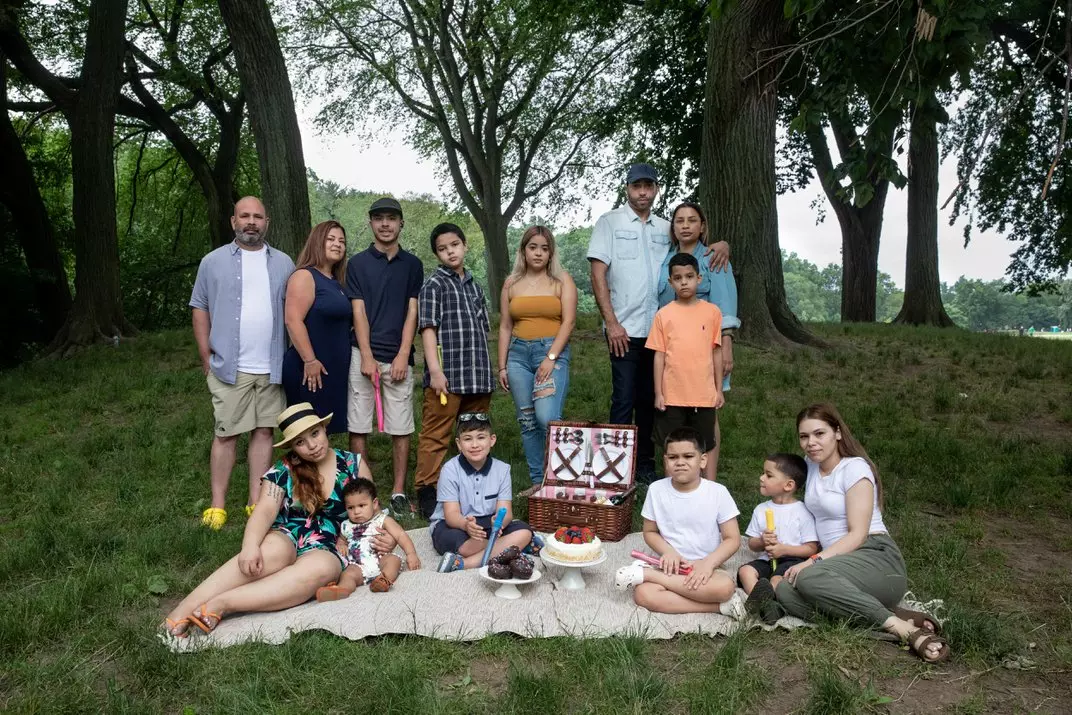 In famyljeportret yn in park, ynklusyf ferskate jonge bern