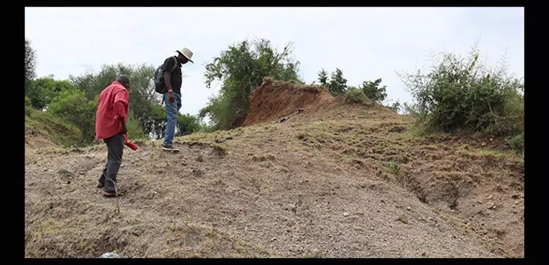 Dve osebi se povzpneta na pust hrib v Keniji