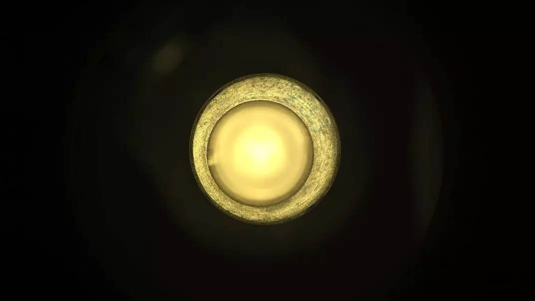 માર્સ રોવરની સેમ્પલ ટ્યુબની અંદરની એક છબી. છબીમાં ટ્યુબ નાના પીળા વર્તુળ જેવી દેખાય છે. ટ્યુબ ખાલી છે.