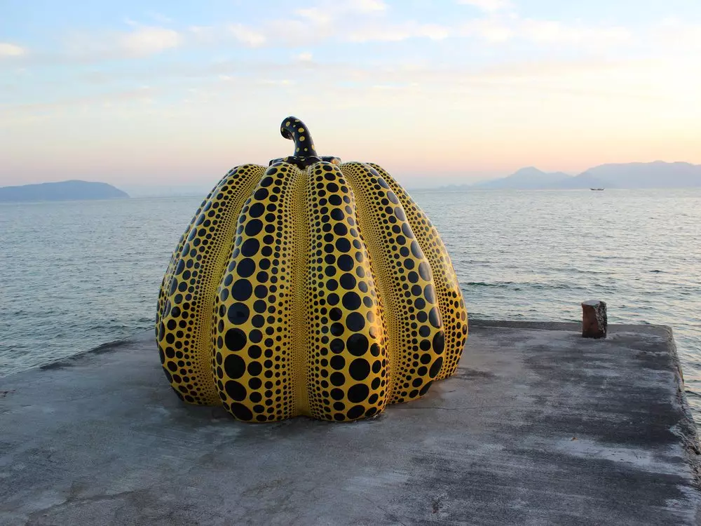 Escultura Yayoi Kusama Pumpkin em um píer