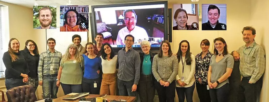 Un groupe de personnes posant pour une photo dans une salle de conférence.