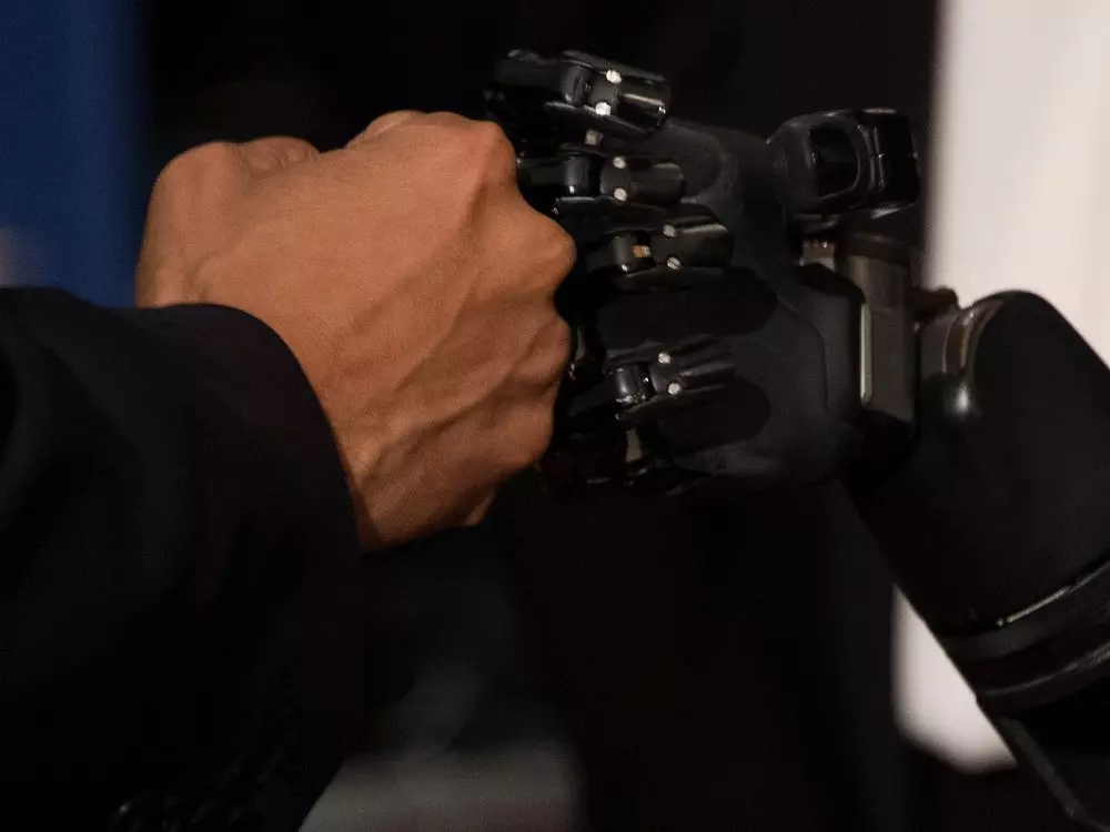 President Barack Obama fist bumps a robotic arm