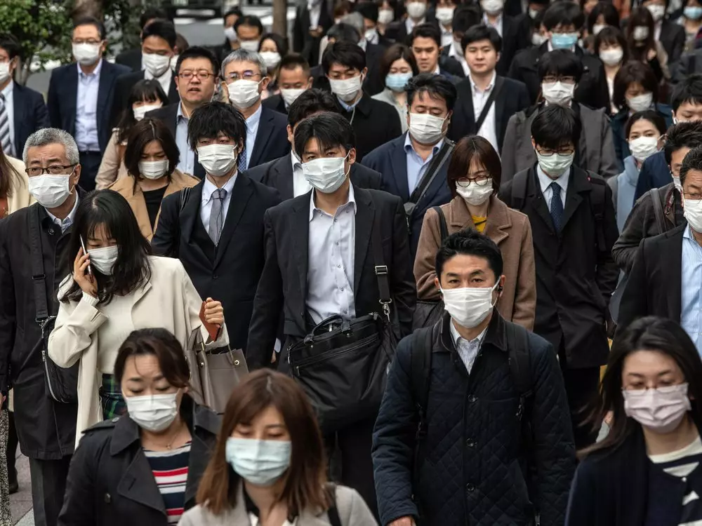 Pendlare som bär masker i Tokyo