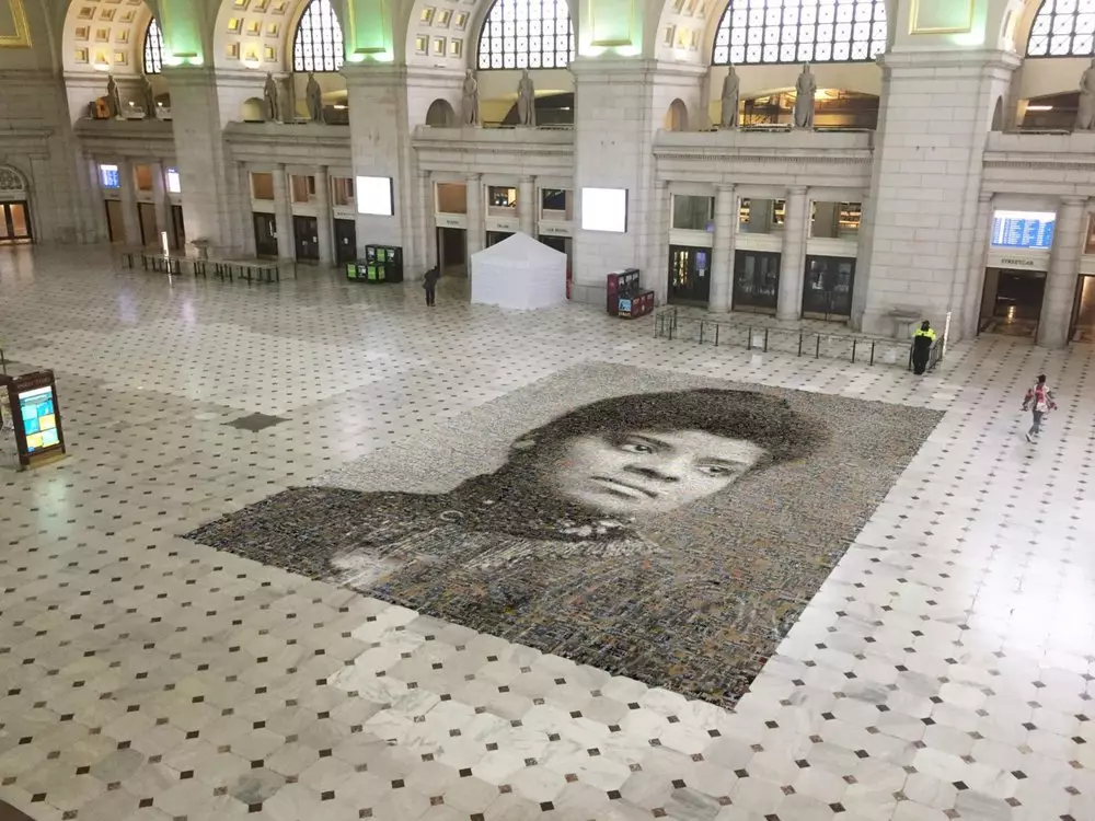 Et luftfoto av mosaikken, med to personer som går i nærheten etter skala; mosaikken tar opp 1000 kvadratmeter gulv i Union Station. Stasjonen er for tiden stort sett tom på grunn av Covid-19-pandemien.