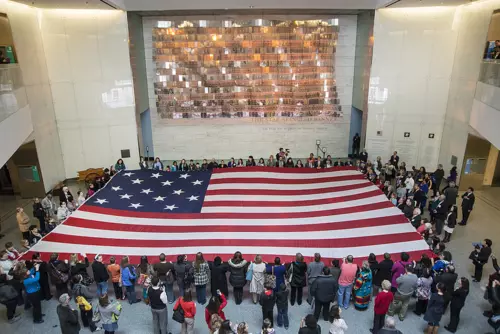 박물관 방문객들은 국가(NMAH)를 부르면서(또는 흥얼거리면서) 국기 접기에 참여합니다.