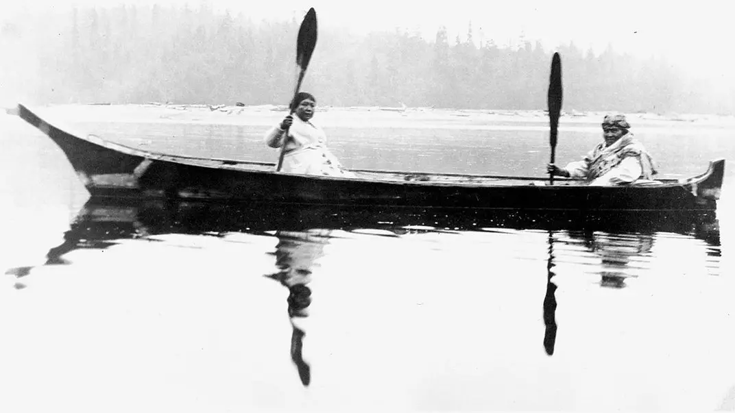 Dúas persoas nunha piragua na auga. Fotografía de arquivo en branco e negro.