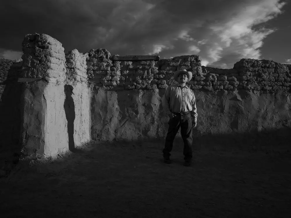 Genízaro Delvin Garcia duro ni awọn iyokù ti Ile-ijọsin Santa Rosa de Lima ti ọrundun 18th. Abiquiú, New Mexico, 2019. (© 2020 Russel Albert Daniels)