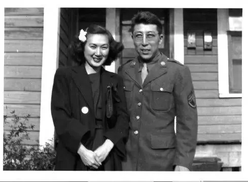 تصویر سیاه و سفید از زوج ایستاده در مقابل خانه